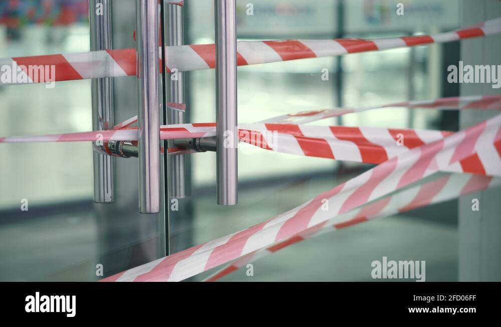 Closed glass door to the mall with a pull-out barrier tape. Closed ...