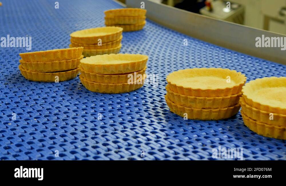 Empty pastry tins at the conveyor belt of a food factory Stock Video ...