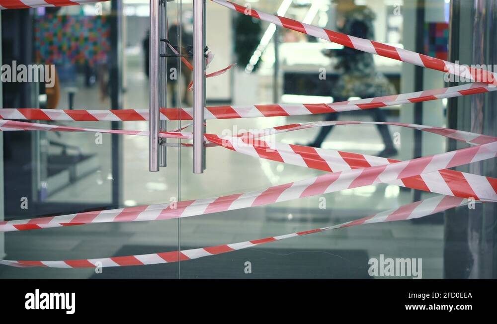 Closed glass door to the mall with a pull-out barrier tape. Closed ...