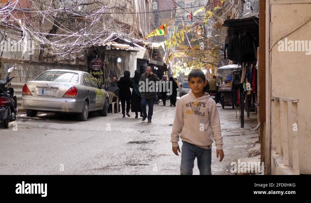 Palestinians walk in an alleyway at Burj Al - Barajneh Palestinian ...