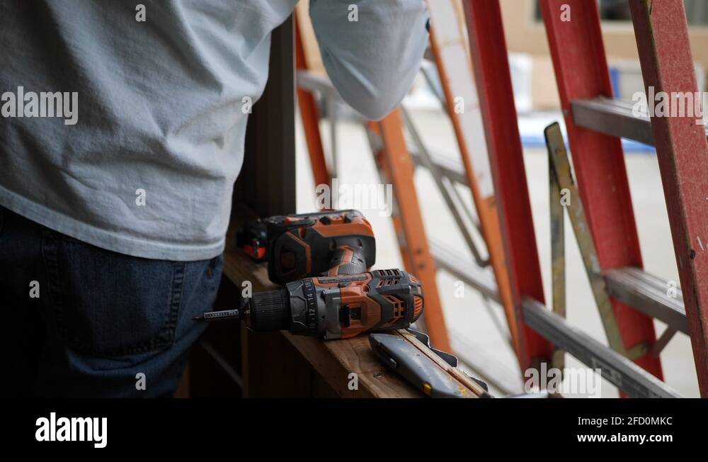 A crew of men construction workers framing and building a tiny house ...