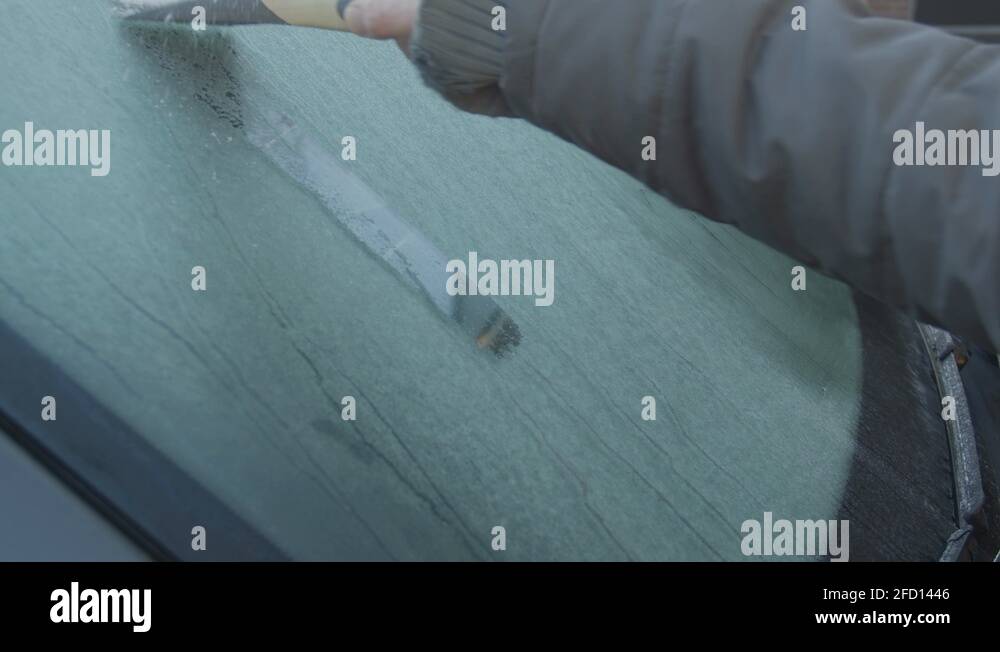 Scratching ice from car window in winter. Filmed in 4K at 60fps Stock ...