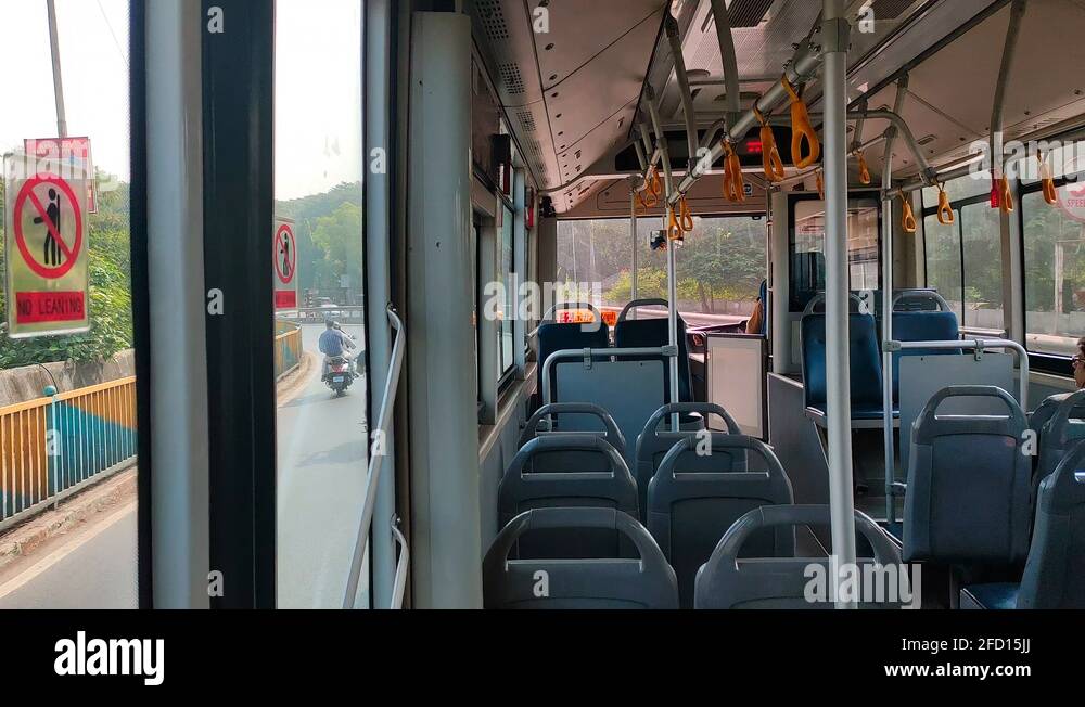 Empty bus crossing over train bridge very few passengers inside the bus ...