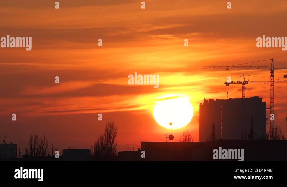 Construction of a high-rise building on a sunset background ...
