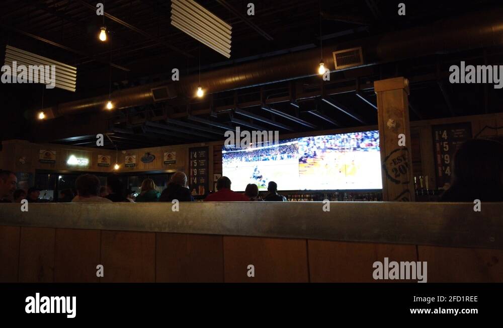 People Eating In Beer Pub Restaurant At Night With Television Screens ...