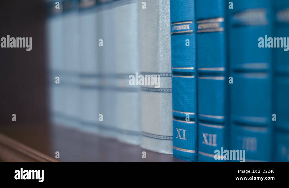Collection of volumes of books of blue color by different writers on a ...