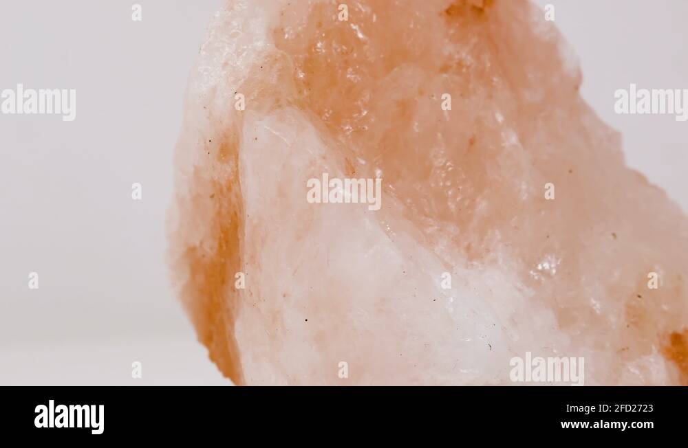 Extremely close view of pink salt rock sample. Rotating back to front ...