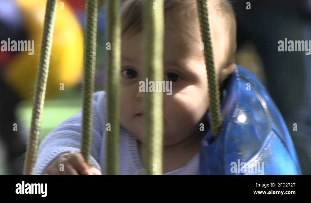 Contemplative Baby at playground swing at park meditative infant ...