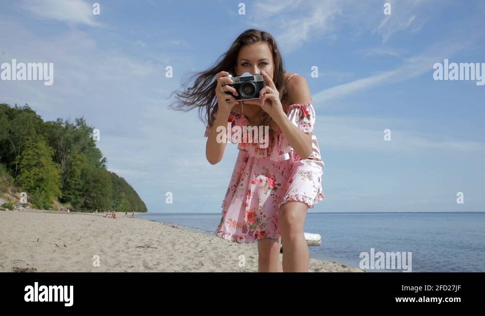Point of view as an attractive young woman takes photos of the viewer ...