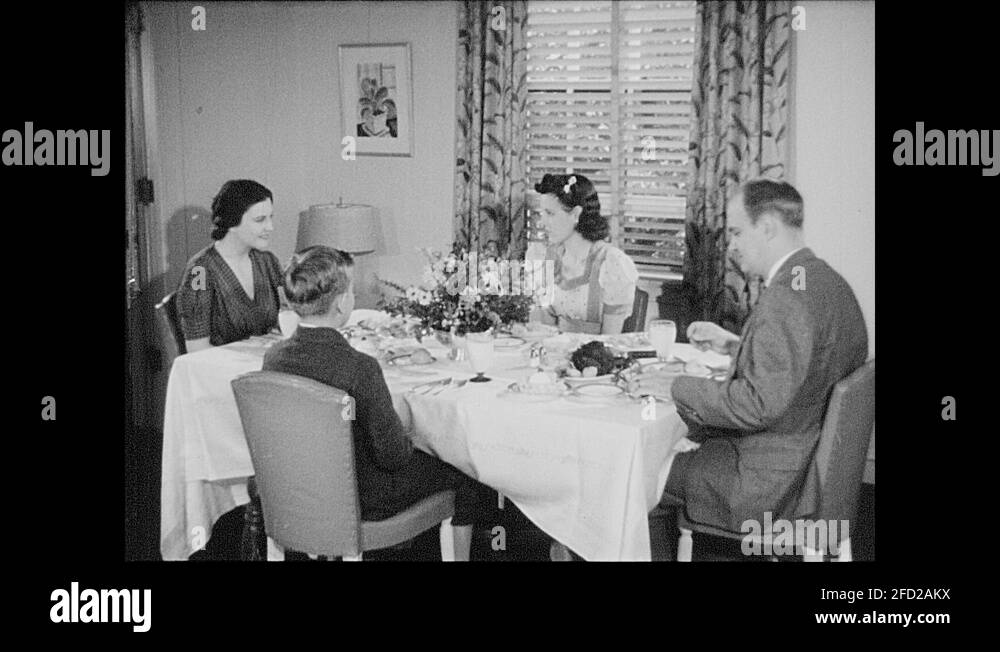 1940s: family sitting around dinner table serving themselves food from ...