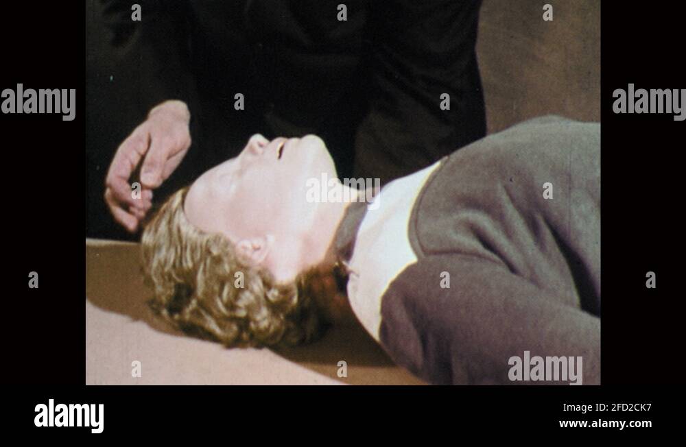 1960s: UNITED STATES: man tilts head of Resusci Anne mannequin in class ...
