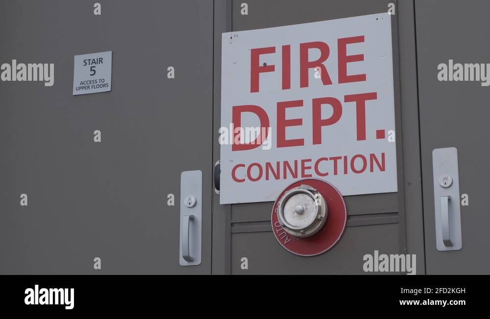 Fire department hose connection and sign on the wall of a building in ...