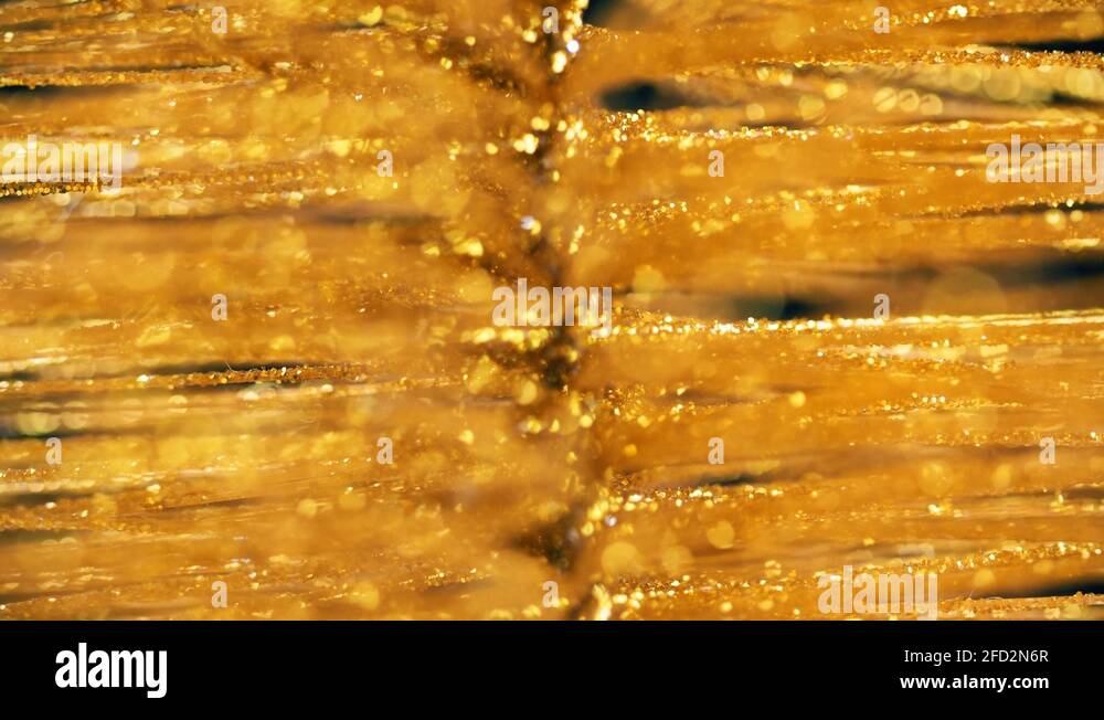 Gold tinsel glitter texture surface on black background. 4k close up ...