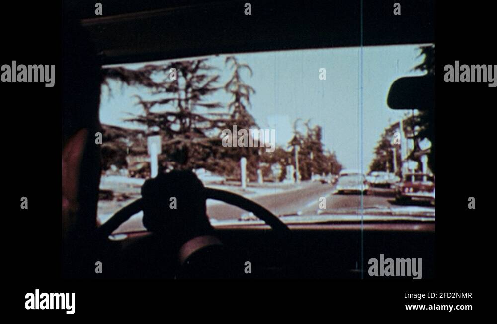 1960s: Man drives car. Hula dancer. Man holds tropical drink. Stoplight ...