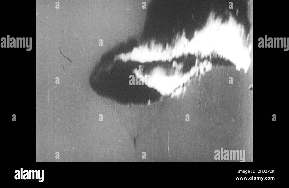 1960s: pilot floating down with burning parachute, anti-air guns firing ...