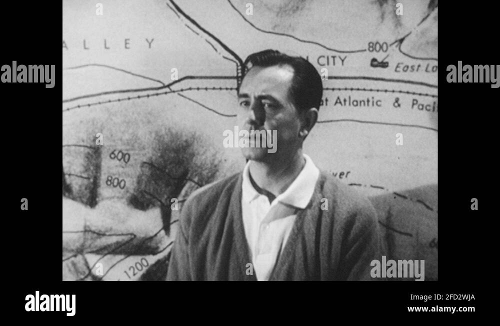 1960s: UNITED STATES: man stands in front of map thinking. Central City ...