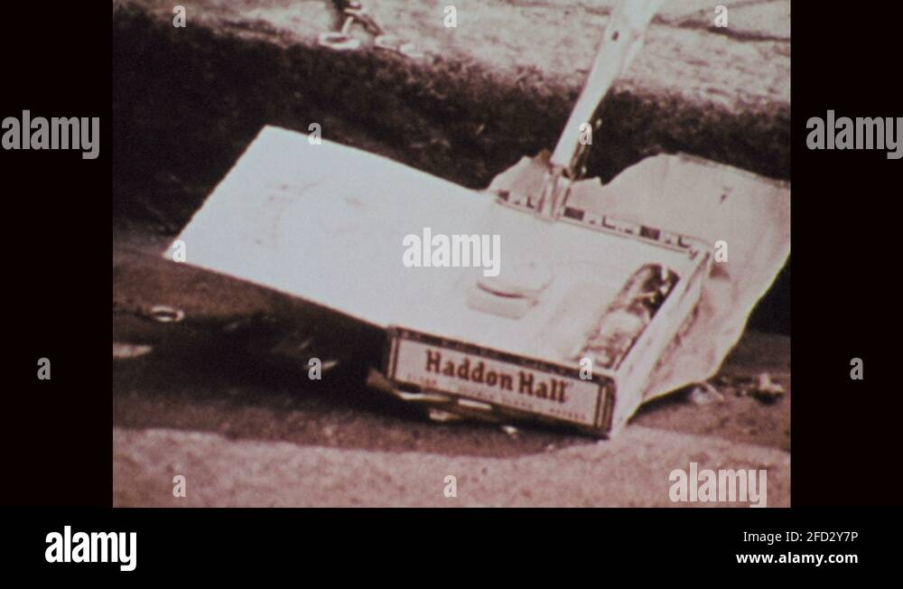 1970s: Suspicious package. Sign for store. Policemen inspect package ...