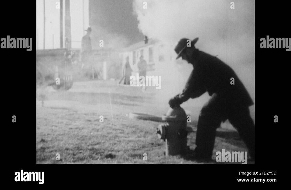 1950s: Fireman turns valve on fire hydrant, building burns, smoke fills ...