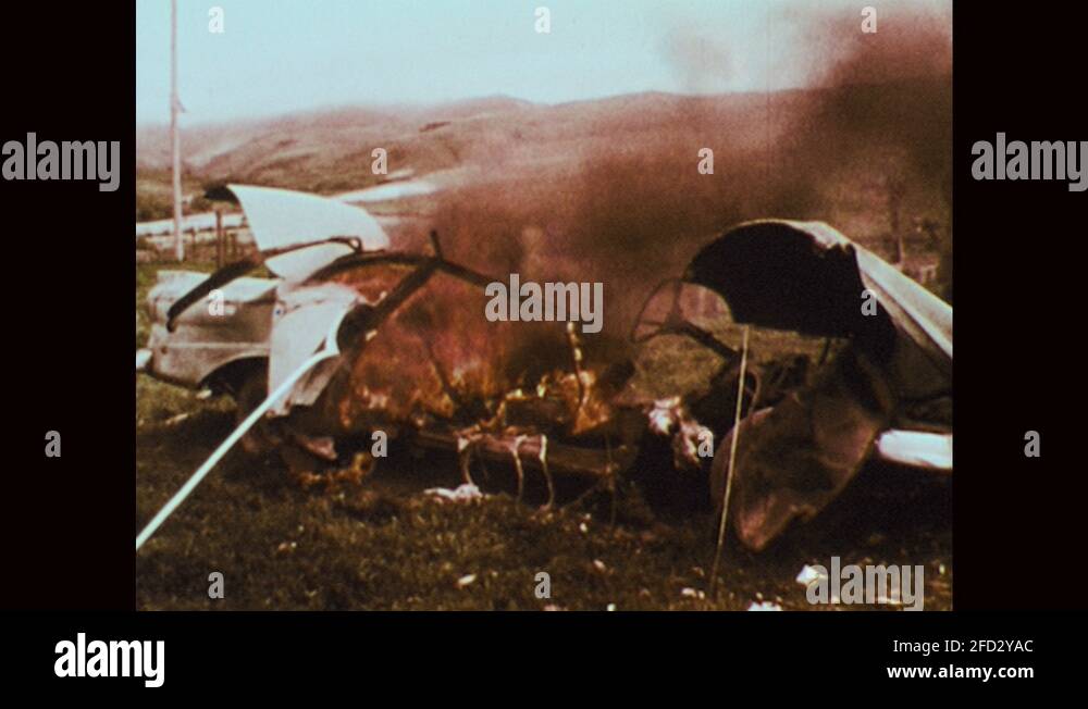 1970s: smoke and fire coming off an exploded car, police officer ...