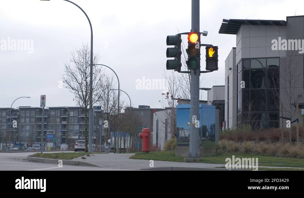 Traffic light on red in residential intersection with a black car ...
