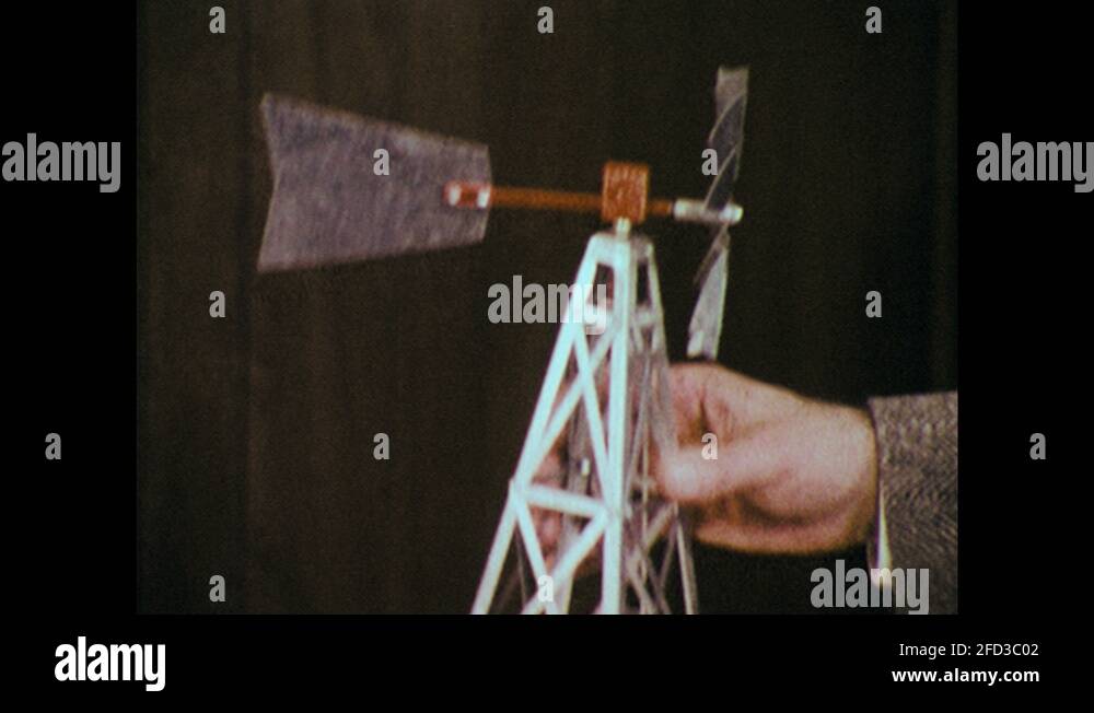 1970s: UNITED STATES: scale model of old farm windmill. Man holds model ...
