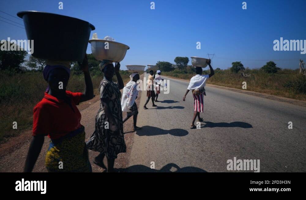 African women carrying buckets with water on their head in Ghana. They ...