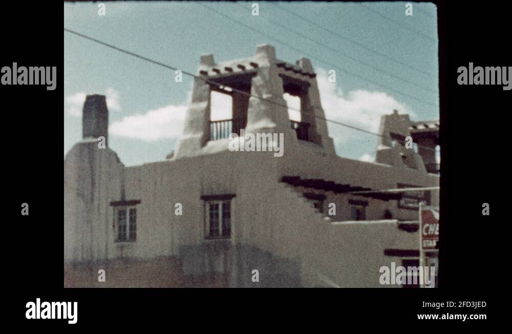 1940s: UNITED STATES: Chevron logo. Man works on building. Lady looks ...