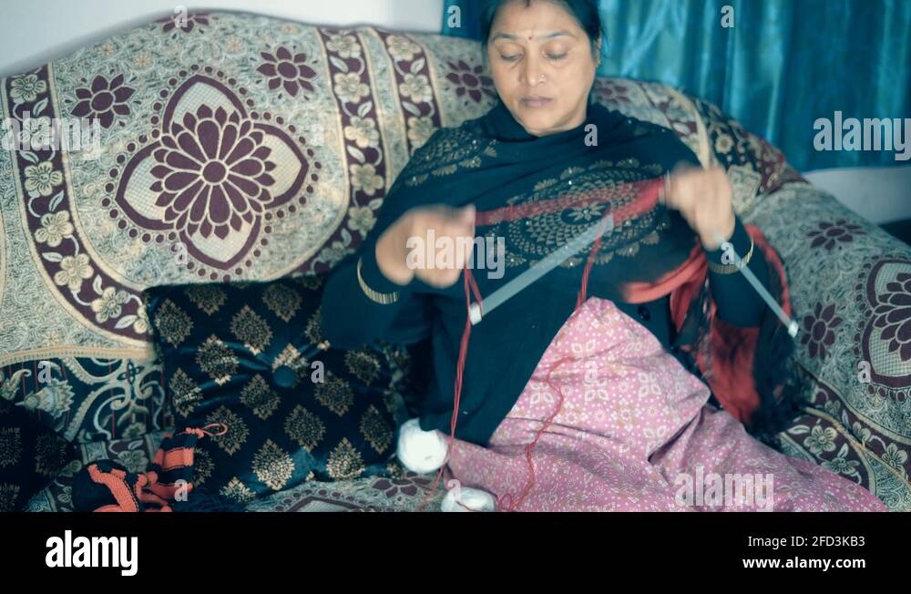 Traditional Indian woman knitting with red wool and two needle crafts ...