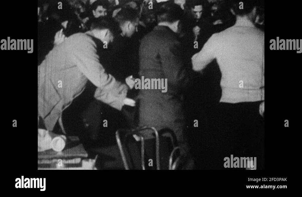 1940s: Crowd pushes and shoves to get out of room. Stadium full of ...