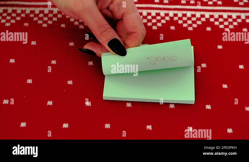 Hand flipping through Post-It notes with change of year against red ...