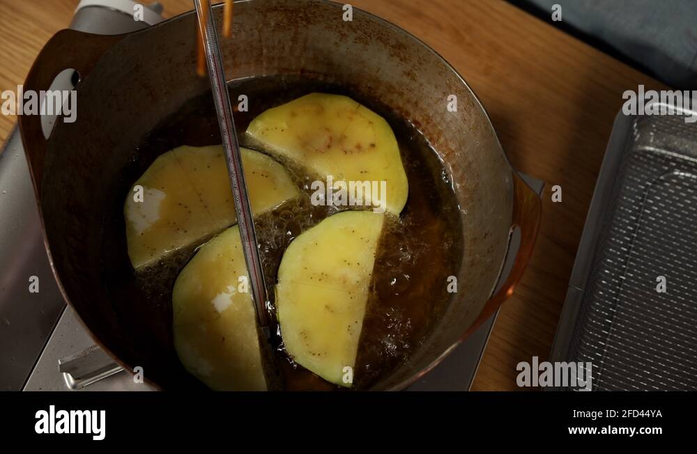 A chef deep frying KAMONASU (Japanese round aubergine) at her home ...