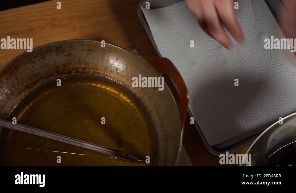 Japanese female chef deep frying KAMONASU (Japanese round aubergine) at ...