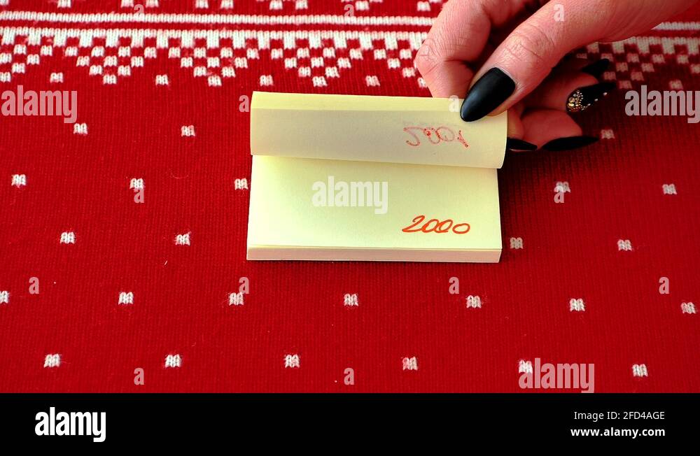 Hand flipping through Post-It notes with change of year in bottom ...