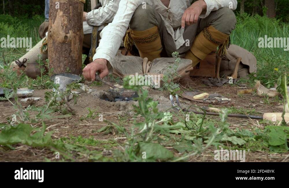 Medieval metal melting pit using bellows and smelting bowl, low angle ...