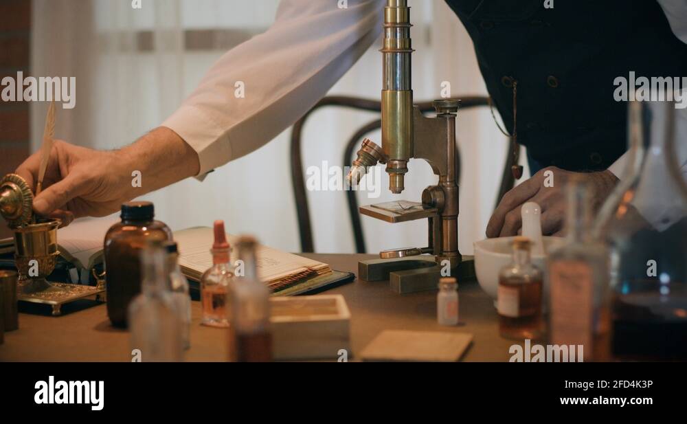 tilt up to Victorian era scientist using a microscope Stock Video ...