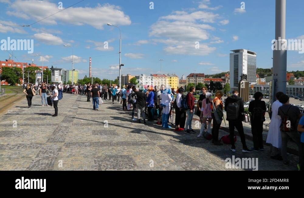 A queue of people is waiting in front of the main gate before entering ...