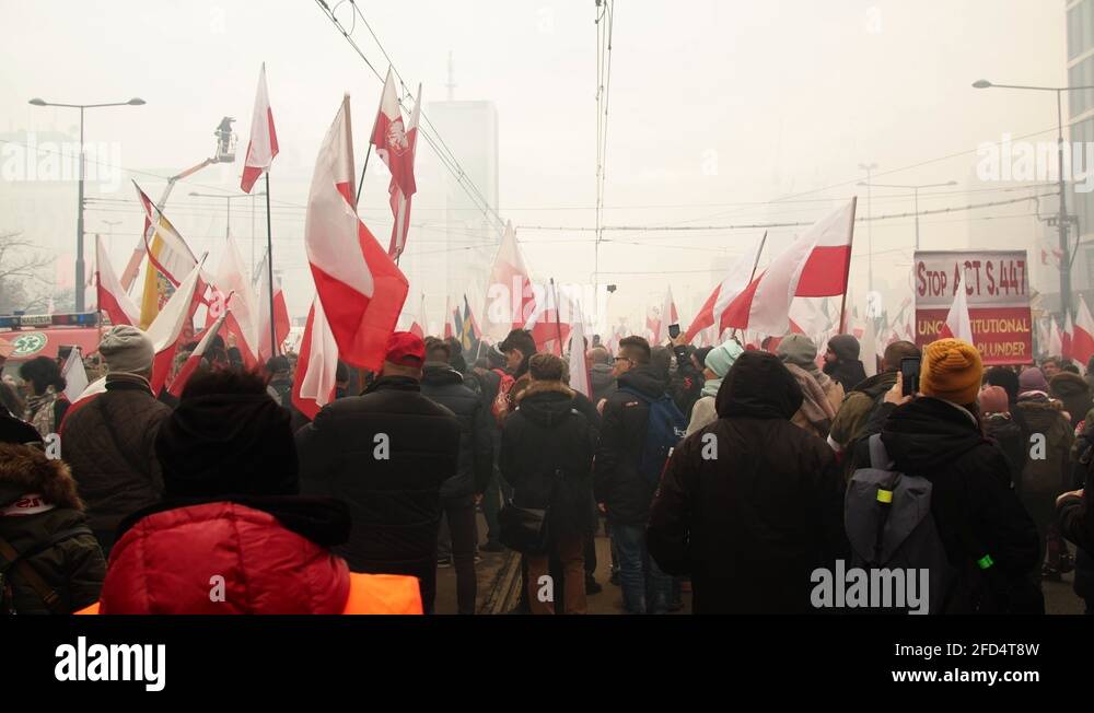 Crowd waiting waving the polish flag over their heads as an ambulance ...