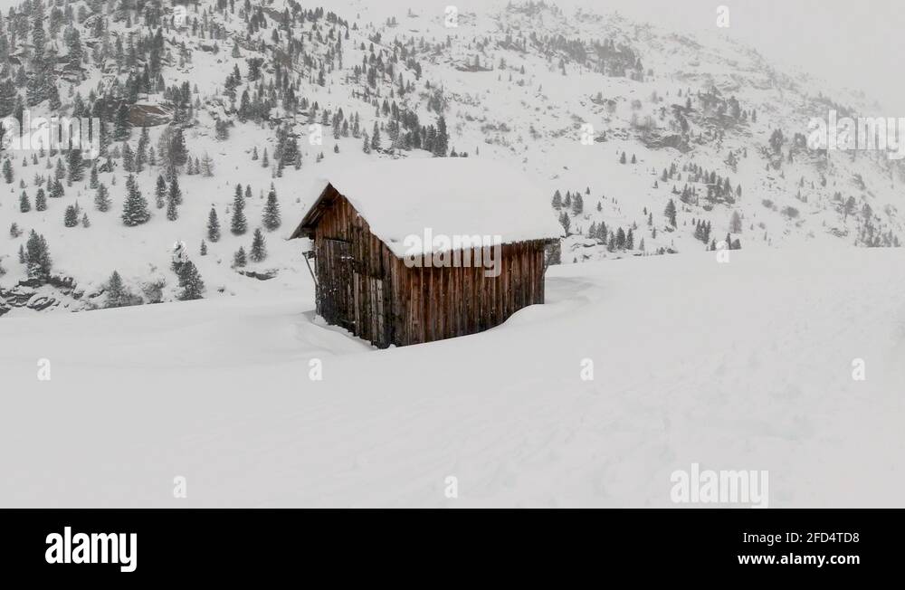 Snowy lonely isolated wooden cabin on heavy snowfall alp mountain ...