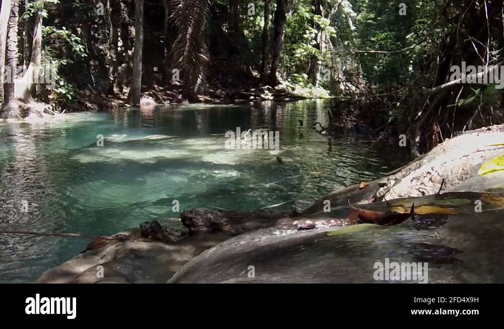 Water running down rocks into turquoise swimming hole in the jungle of ...