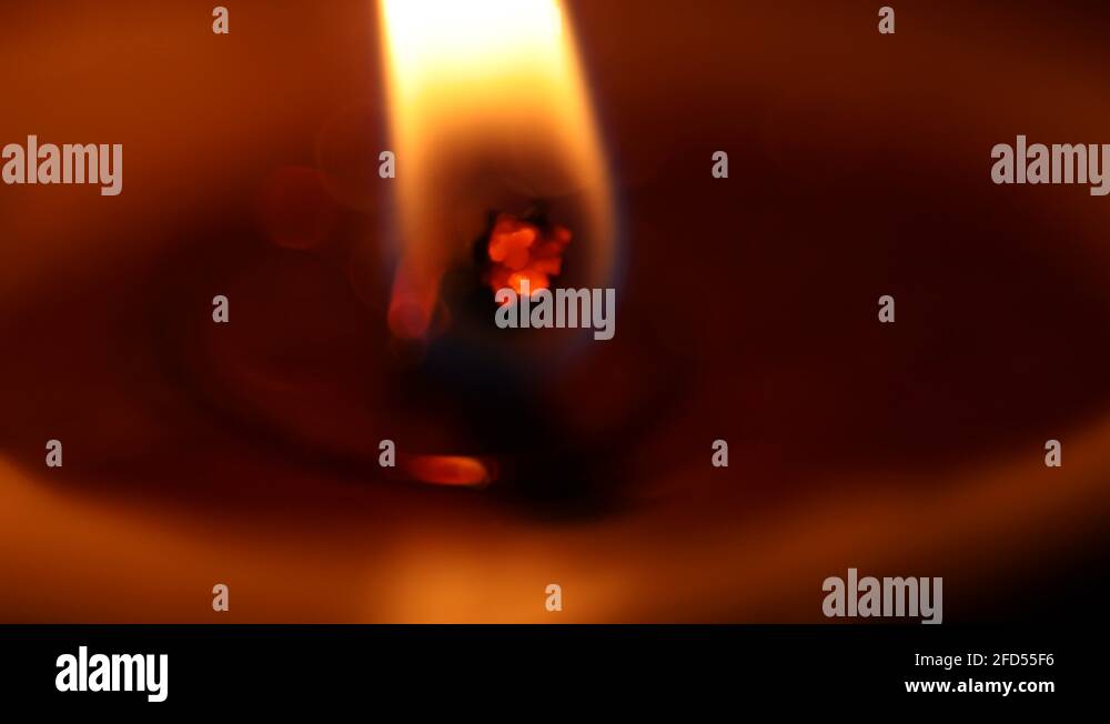 Extreme close up glowing butter thread of a burning butterlamp. Fire in ...