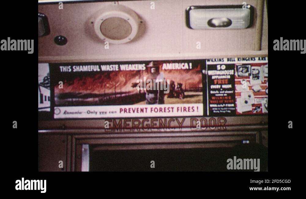 1950s: Smokey the bear sign inside bus. Boy scouts looks at poster on ...