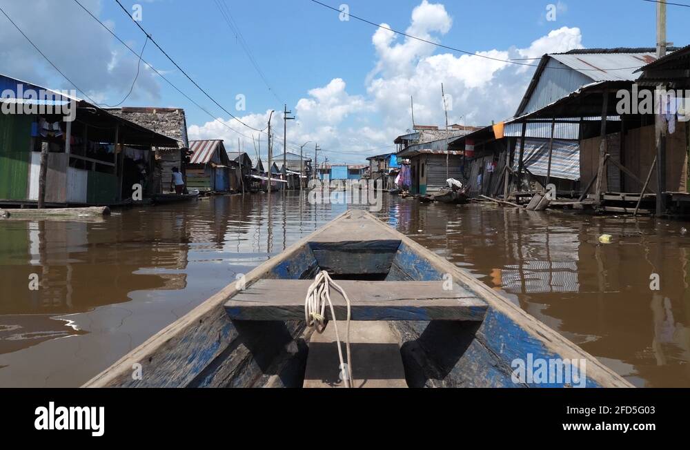 Wooden boat ride through a floating village along the Amazon river in ...