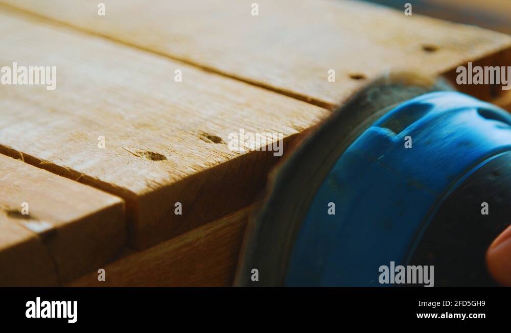A Young Woman Scraping The Rough And Uneven Edges Of A Wooden Pallet ...