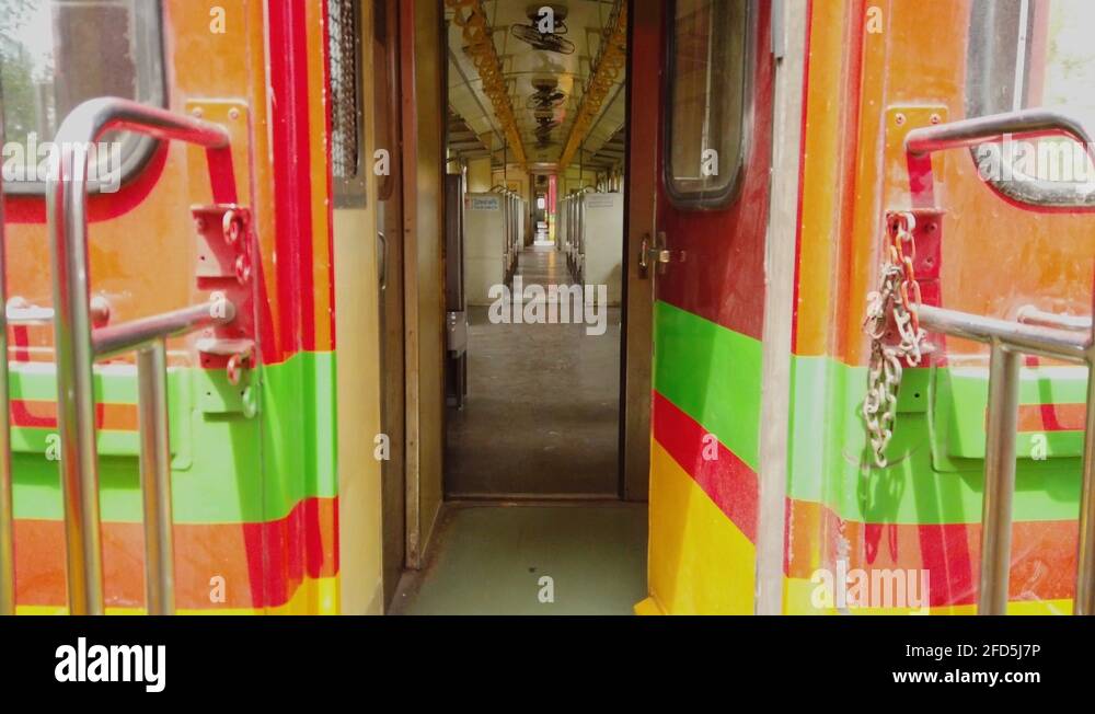 Vestibule view of train cars connected and a long empty aisle and seats ...