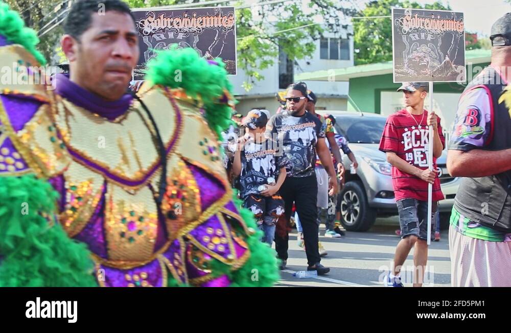 people in scary demon carnival costumes walk on dominican city street ...