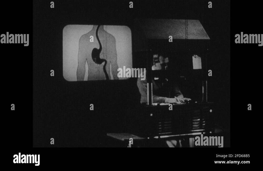 1960s: Person talks in classroom at overhead projector with image of ...