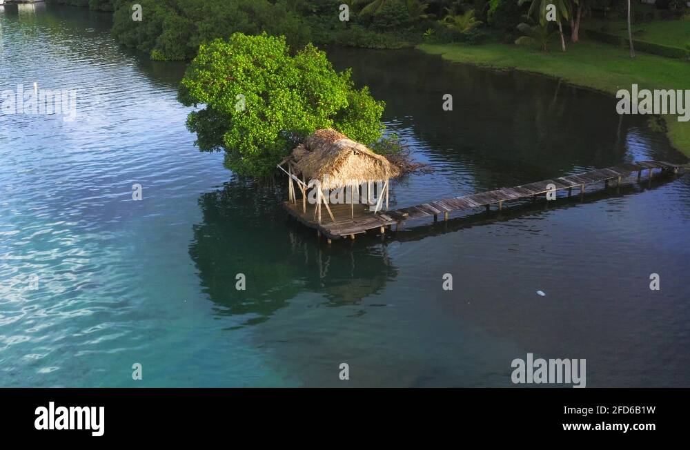 Simple paradise wooden bamboo thatched roof hut cabana & jetty on ...