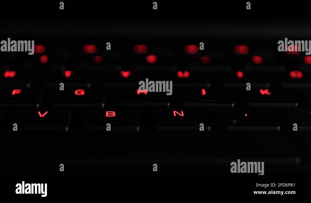 illuminated keyboard buttons letters in RGB colors on modern black ...