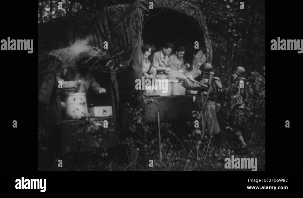 1940s: UNITED STATES: soldiers with mess tins receive hot meal on ...