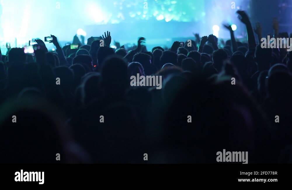 Music concert on stage and crowd clapping in the audience, cheering ...